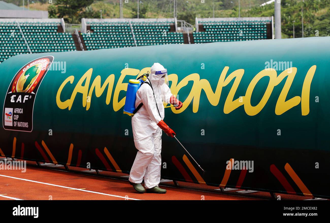 A official wearing PPE sprays the players bench with disinfectant spray ...