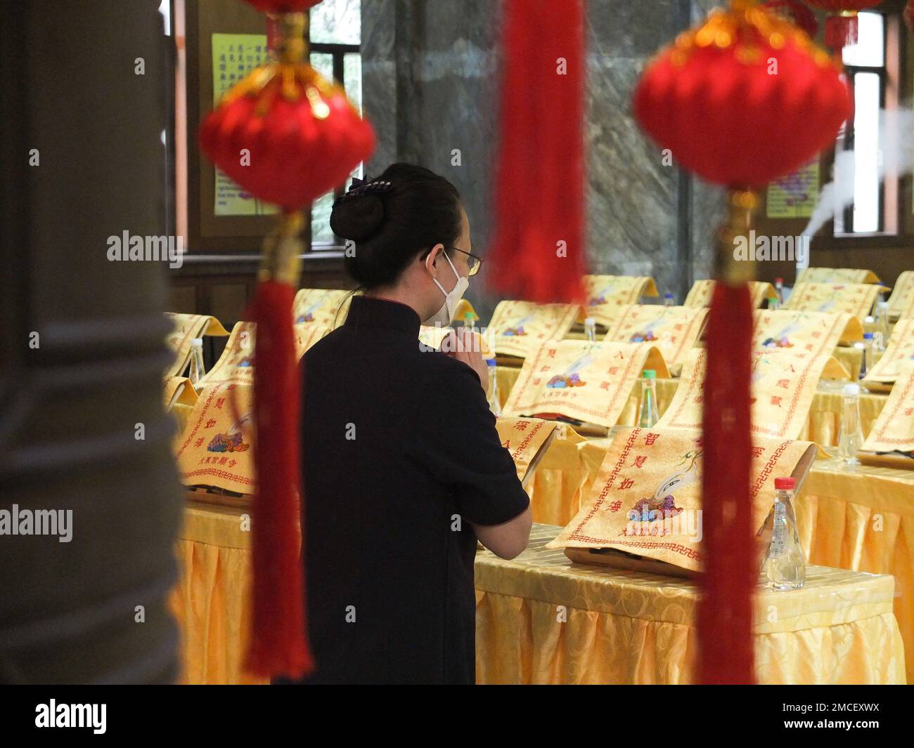 A Chinese woman praying inside the prayer hall of the Seng Guan Temple ...