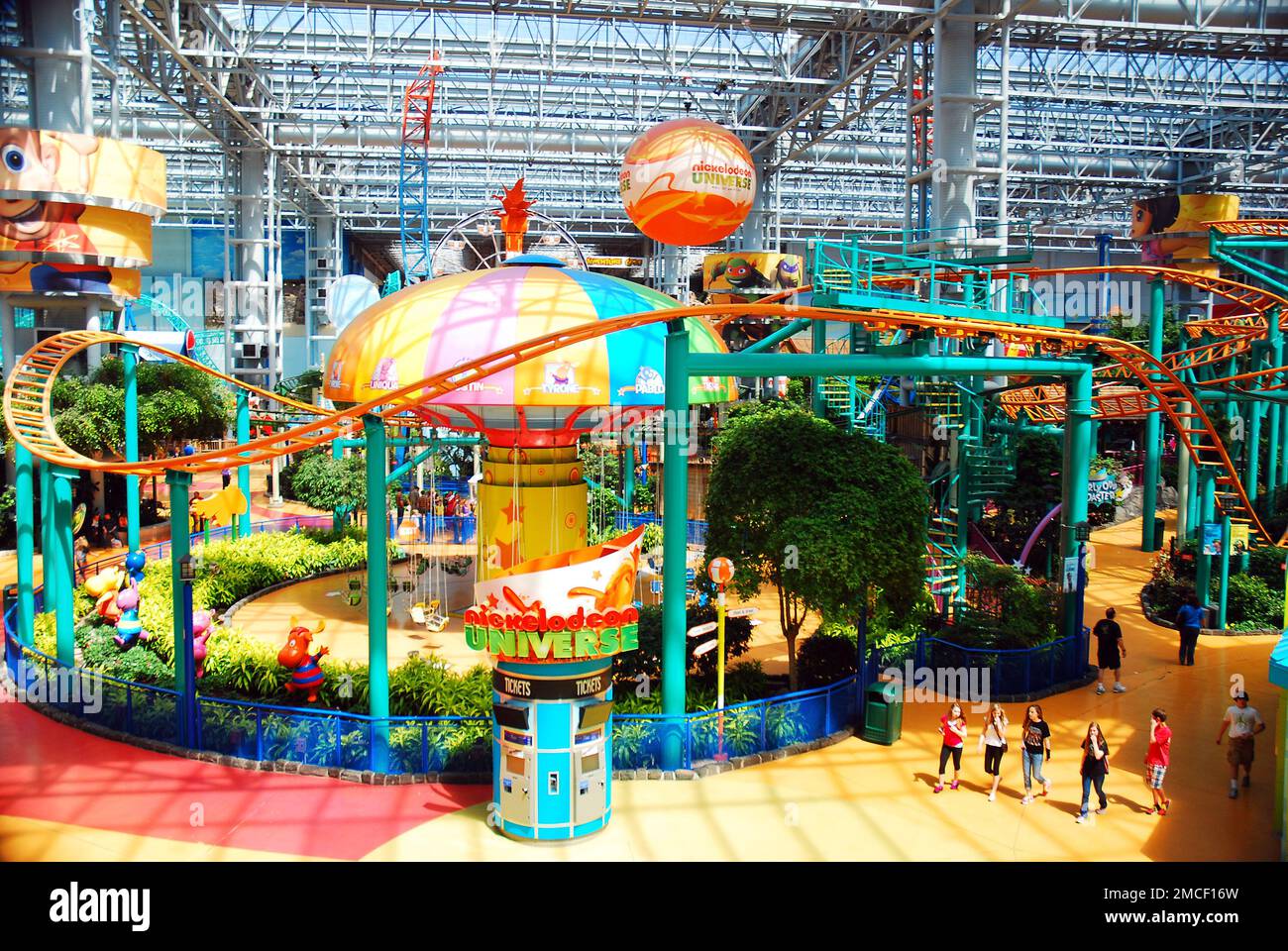 A group of teenage girl friends stroll the indoor rollercoaster and ...