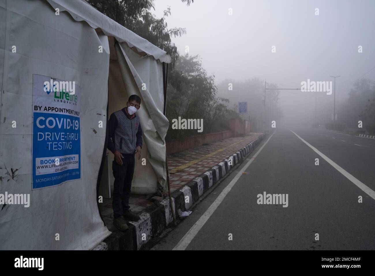 A health worker stands by a drive-through COVID 19 testing post amidst ...