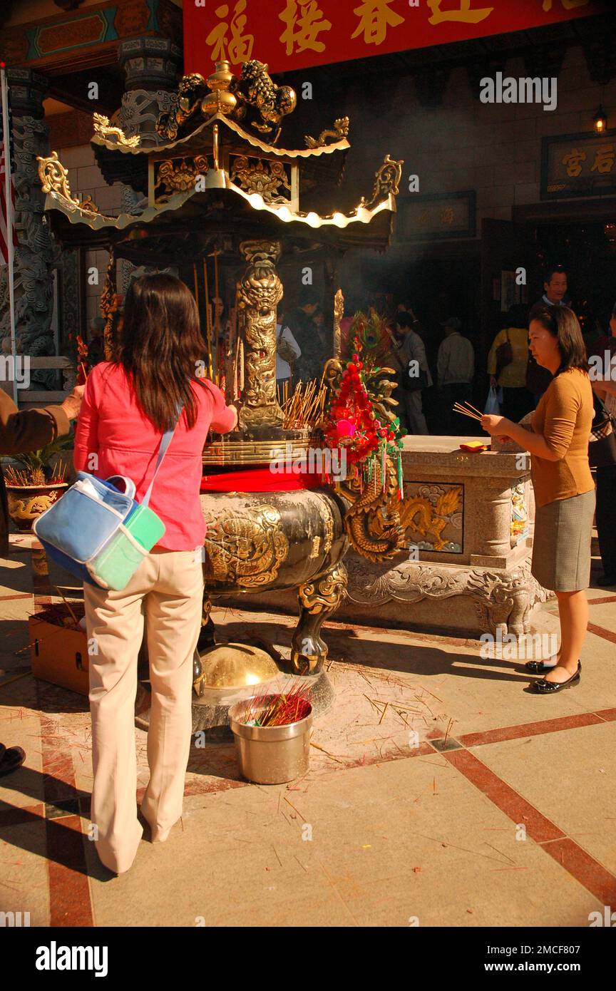 Two asian women offer prayers during a Chinese New Year celebration in ...