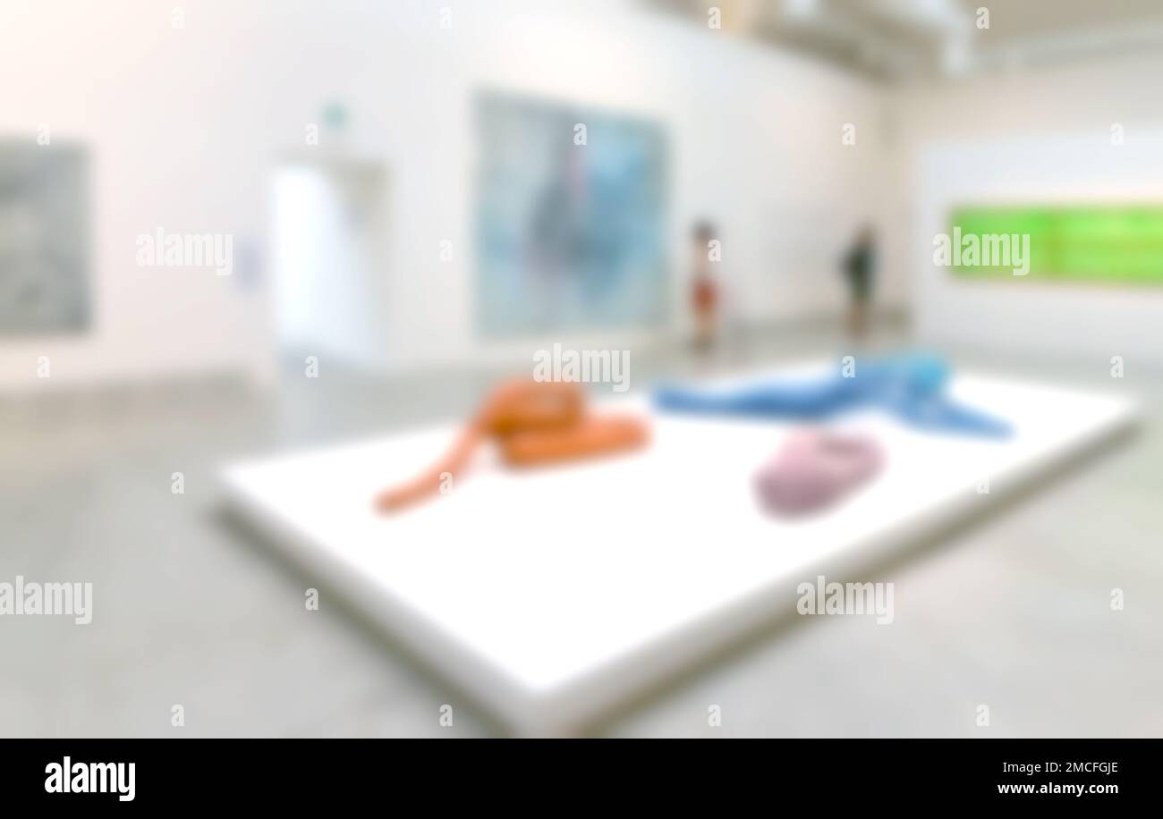 Spectator looking at paintings and sculpture in Art exhibition gallery ...