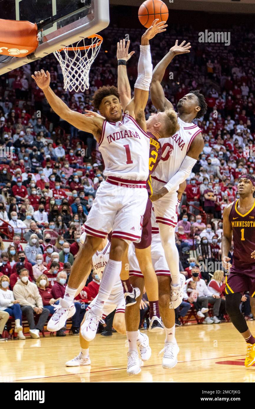 Minnesota guard Luke Loewe (12), center, has a shot deflected by ...