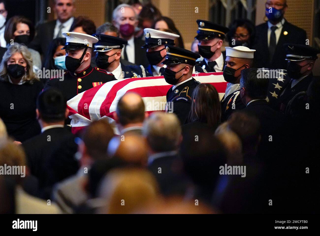 A military honor guard carries the flag-draped casket of former Senate ...