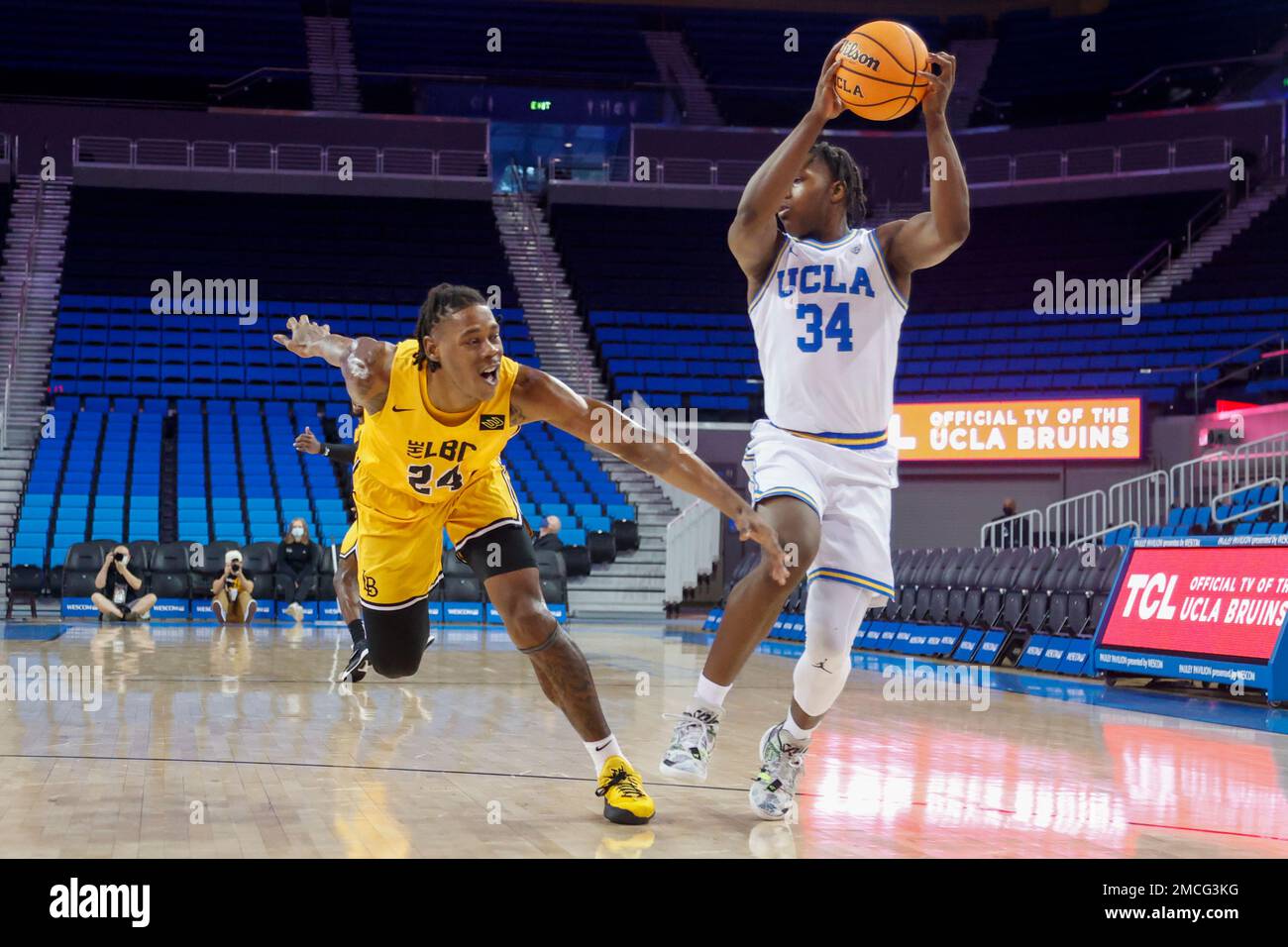 UCLA guard David Singleton (34) is defended by Long Beach State forward ...
