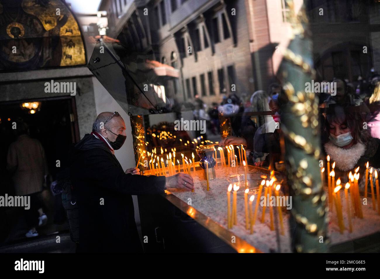 Orthodox Christian faithfuls light candles during the Epiphany Mass at ...