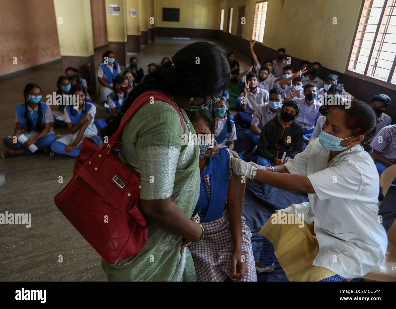 An Indian teen reacts as she receives Covaxin COVID-19 vaccine at a ...