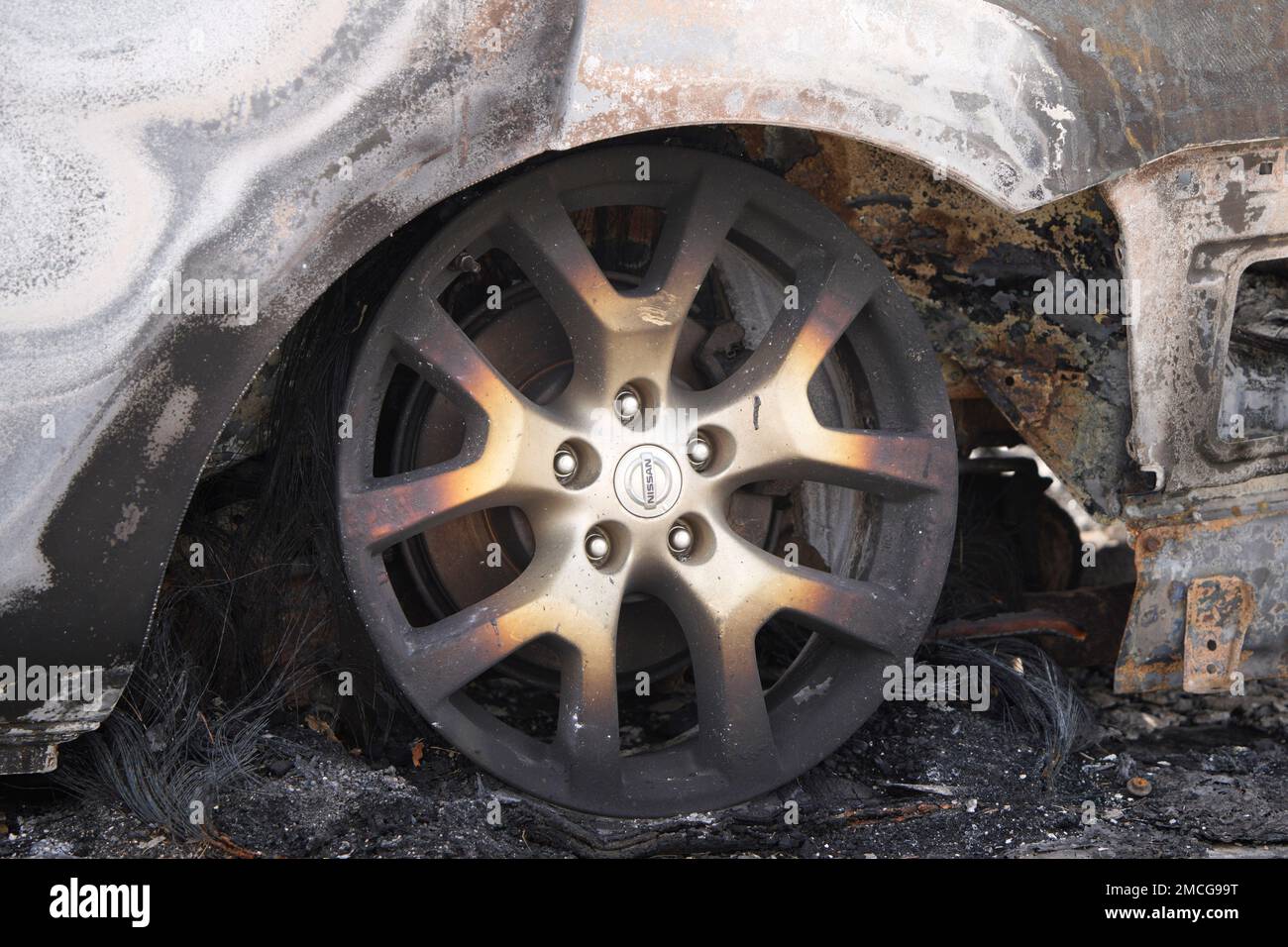 Burn marks scar an alloy wheel on the hulk of a charred vehicle as it ...