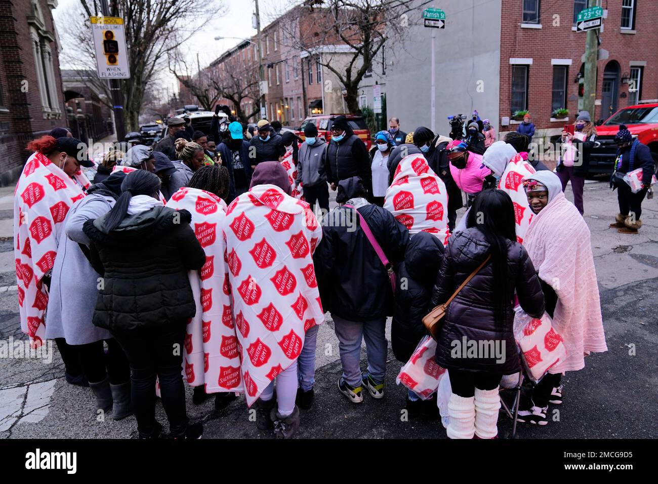 People pray near the scene of a deadly row house fire, Wednesday, Jan ...