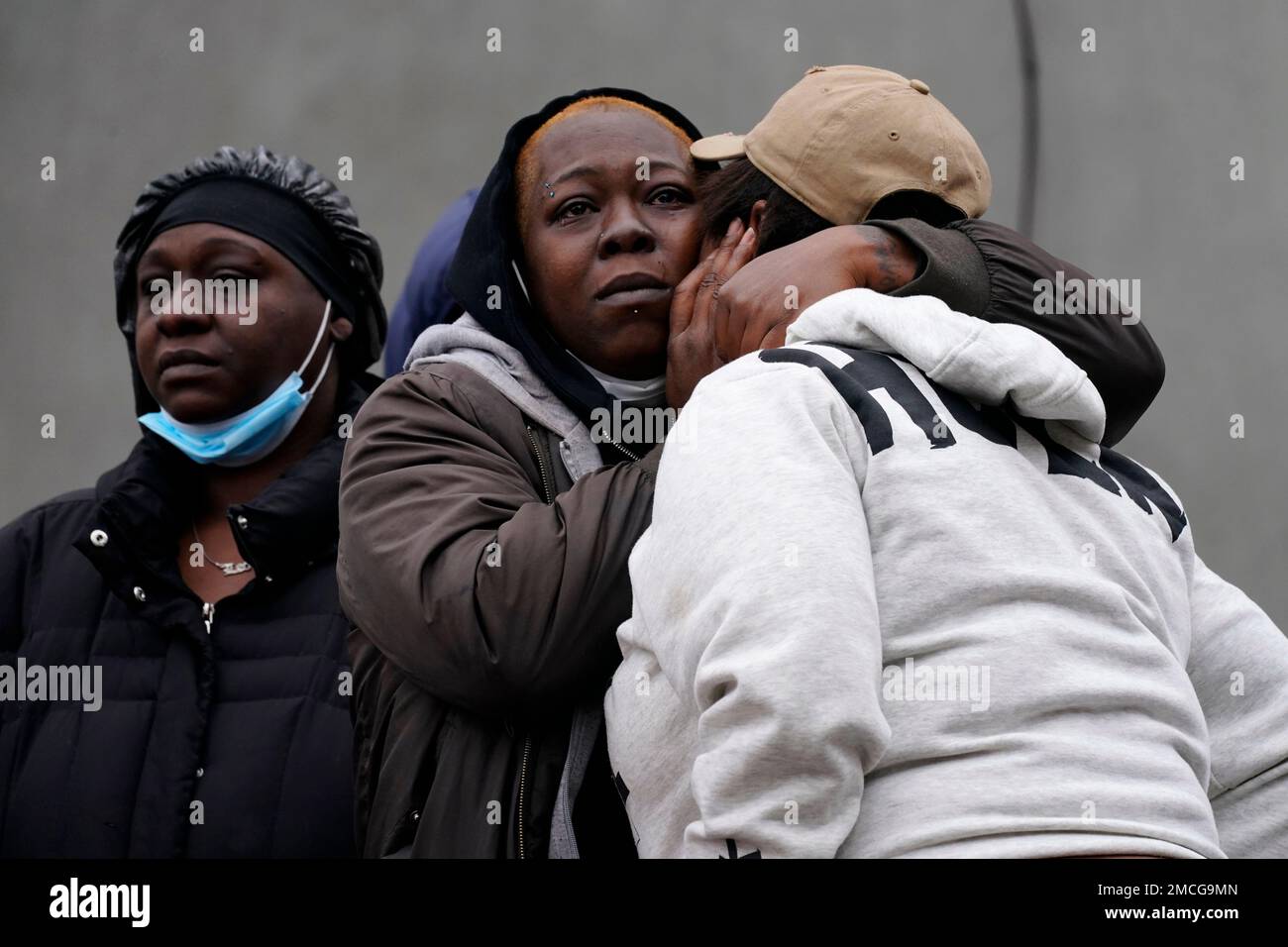 People react near the scene of a deadly row house fire, Wednesday, Jan ...