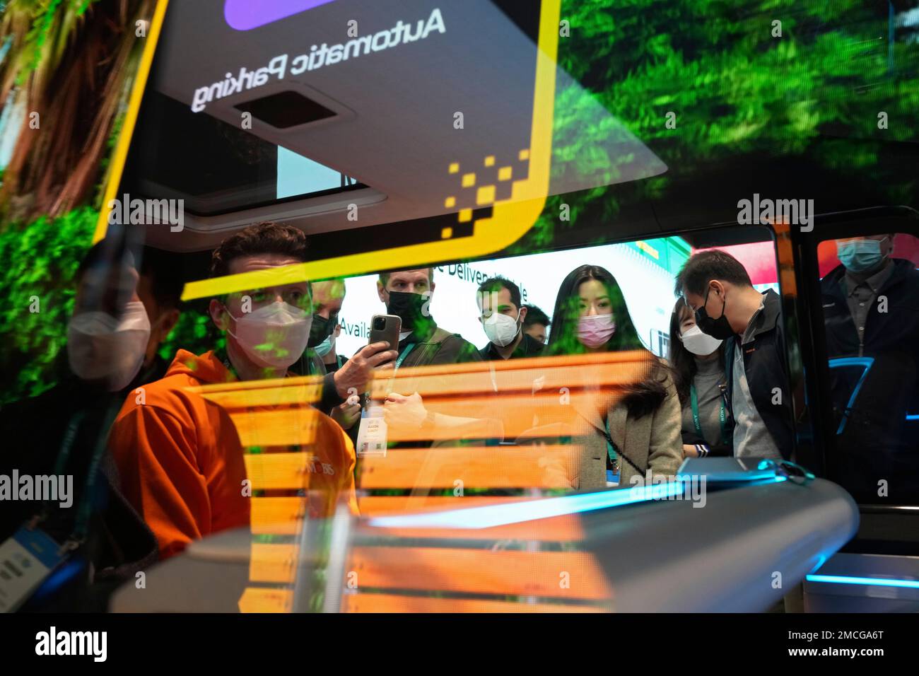 Attendees learn about the M.Vision Pop electric mobility vehicle at the Hyundai Mobis booth ...