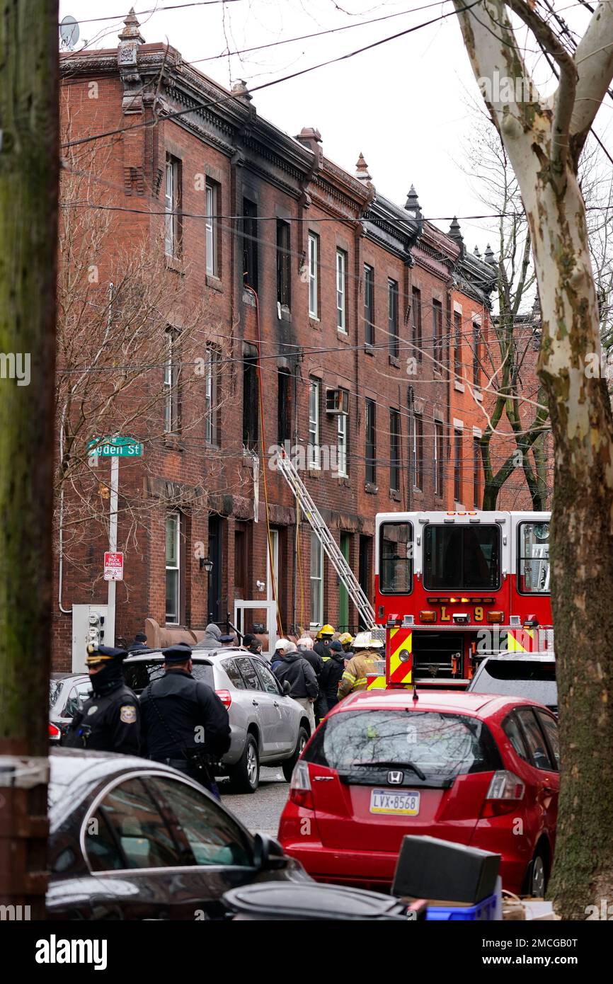Philadelphia firefighters and police work at the scene of a deadly row ...