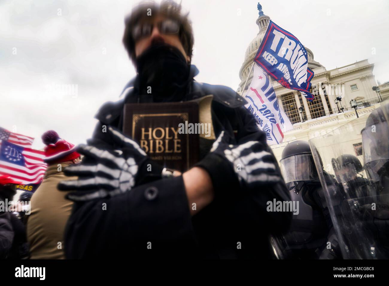 A Trump supporter holds a Bible as he gathers with others outside the ...
