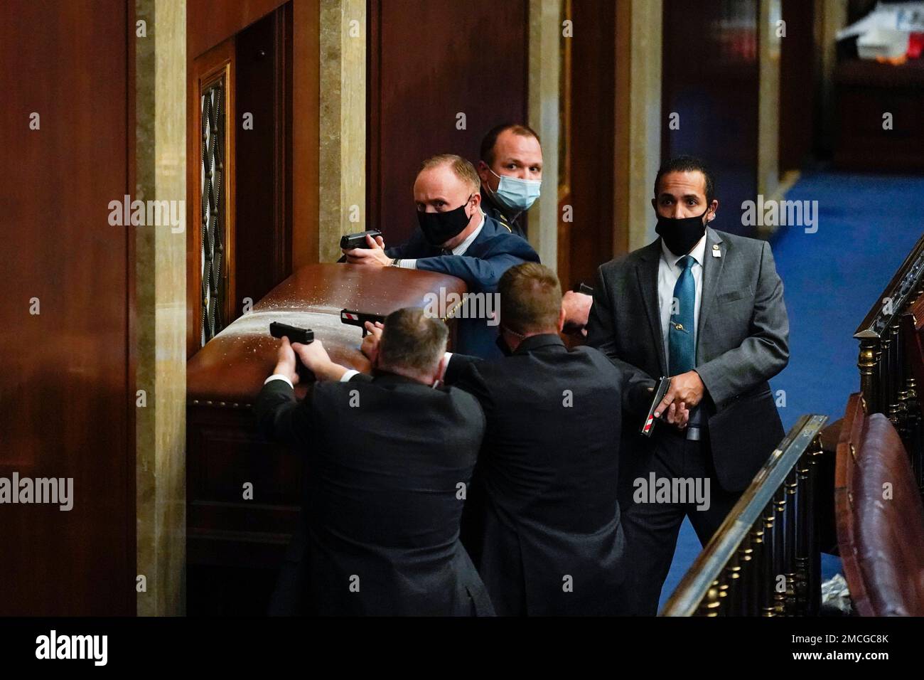 FILE - U.S. Capitol Police with guns drawn stand near a barricaded door ...