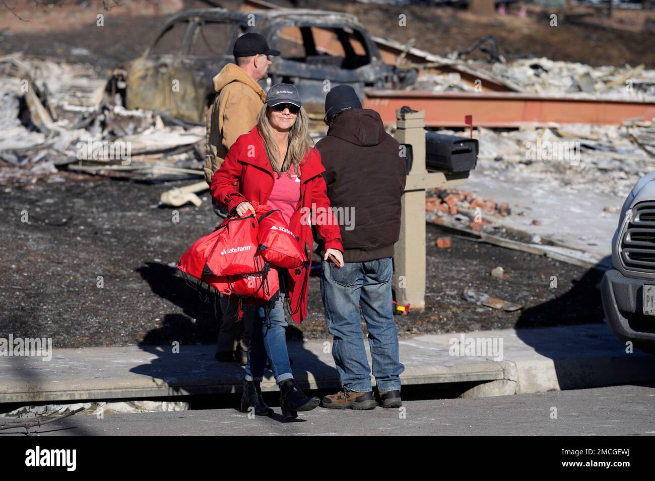 Michal Brower of State Farm Insurance carries bags of supplies to ...