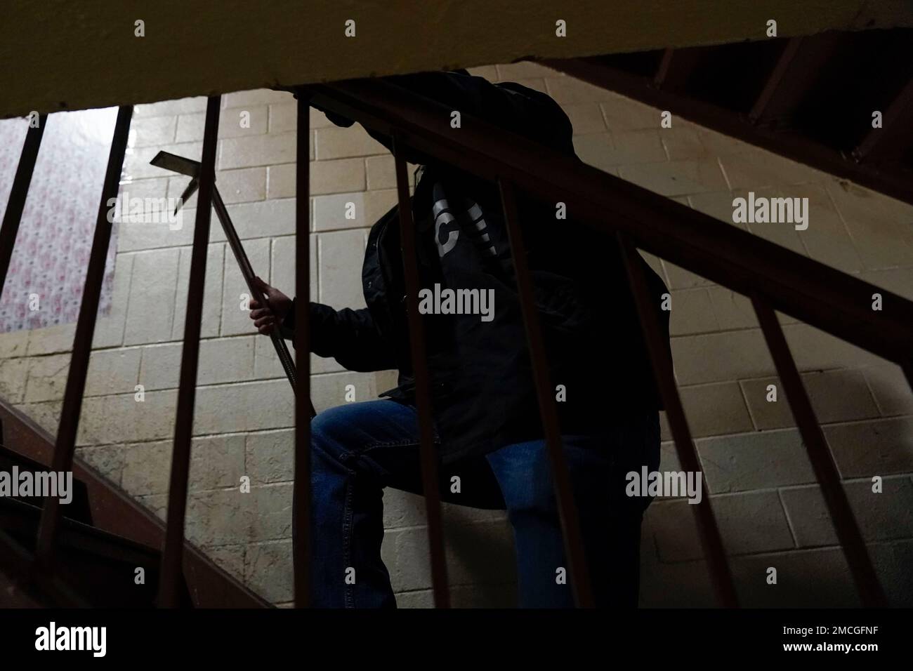 Police officers enter a building during an operation to apprehend ... Police officers enter a building during an operation to apprehend ...