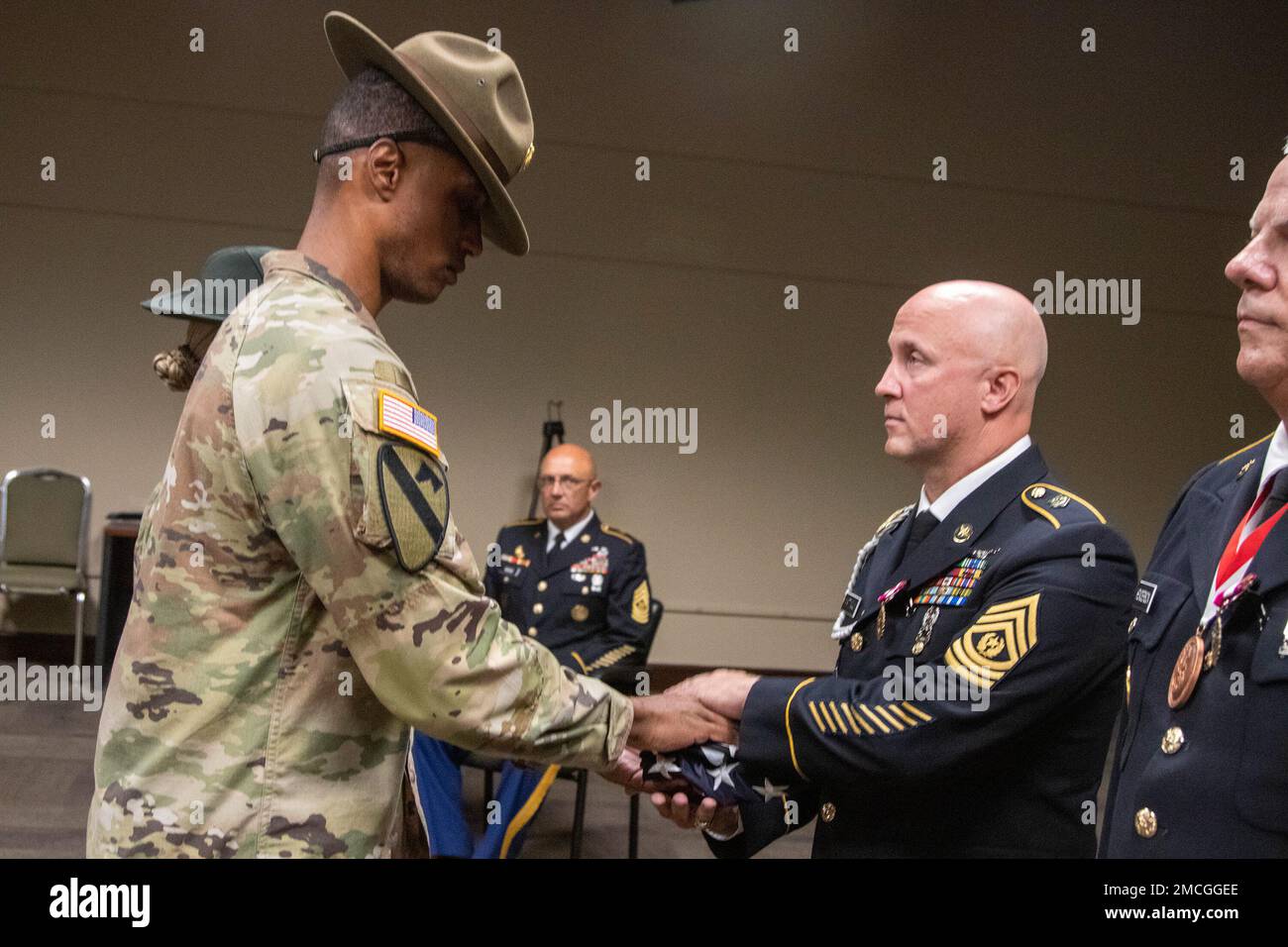 Army Reserve drill sergeant Staff Sgt. Jeffrey Ousley, left, presents the American flag to ...