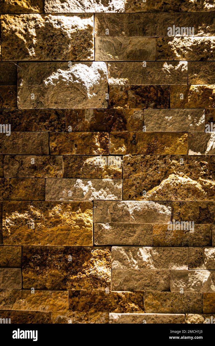 Close up of a granite stacked stone wall texture in beige and orange ...