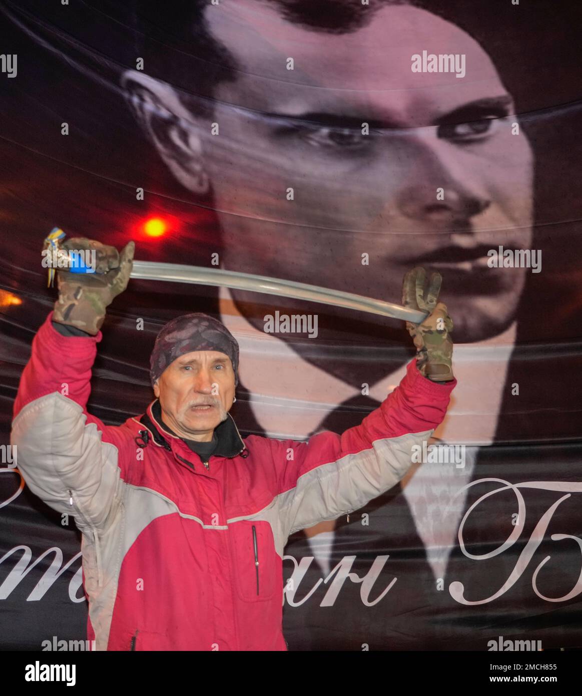 An activist of nationalist party waves saver at a portrait of Stepan ...