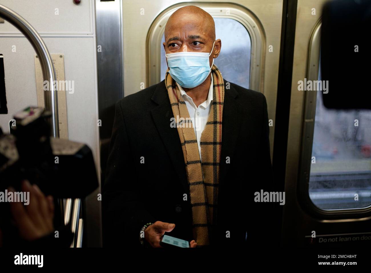 New York City Mayor Eric Adams talks to reporters while riding the ...