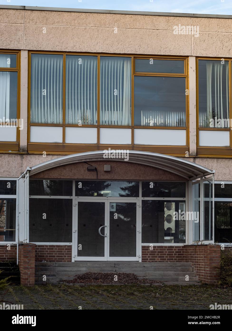 Abandoned school building entrance. Autumn leaves lying on the stairs ...