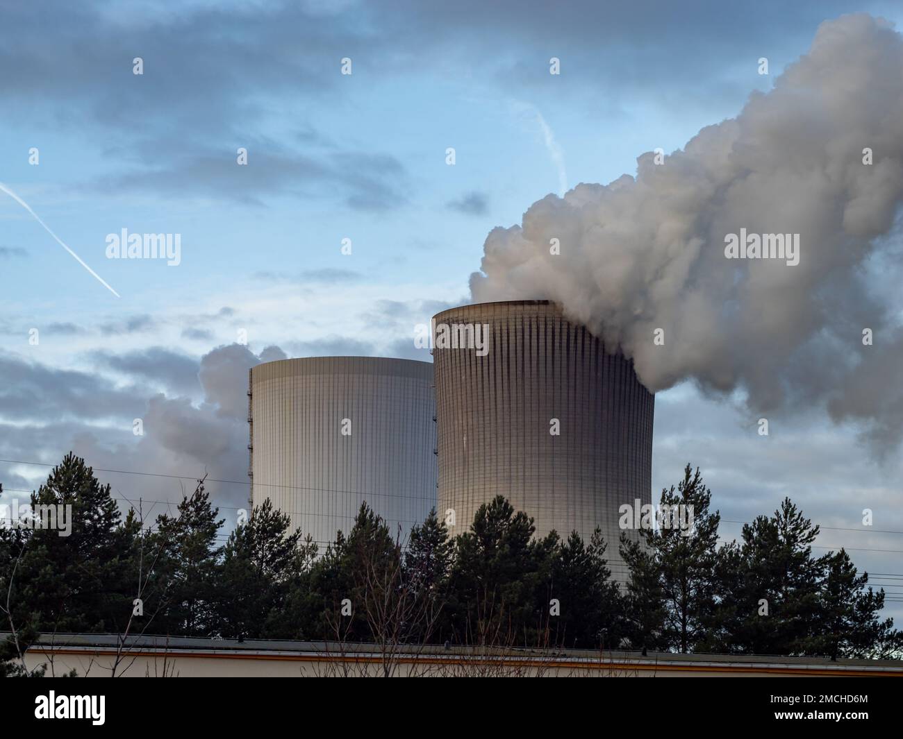Dark smokestack out of a cooling tower of a power plant is polluting ...