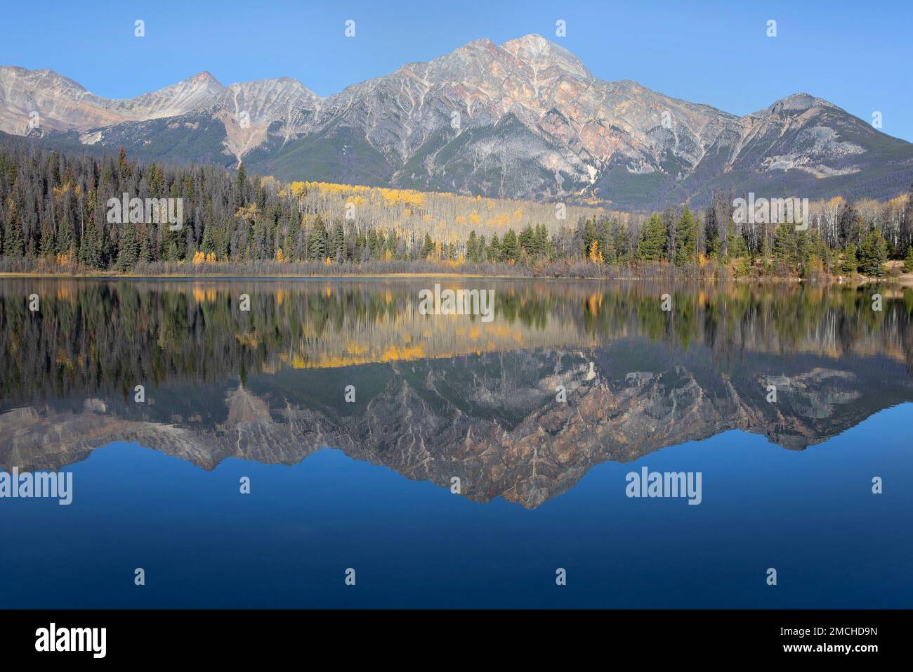 Pyramid Mountain and reflection in Pyramid Lake with clear blue sky in ...