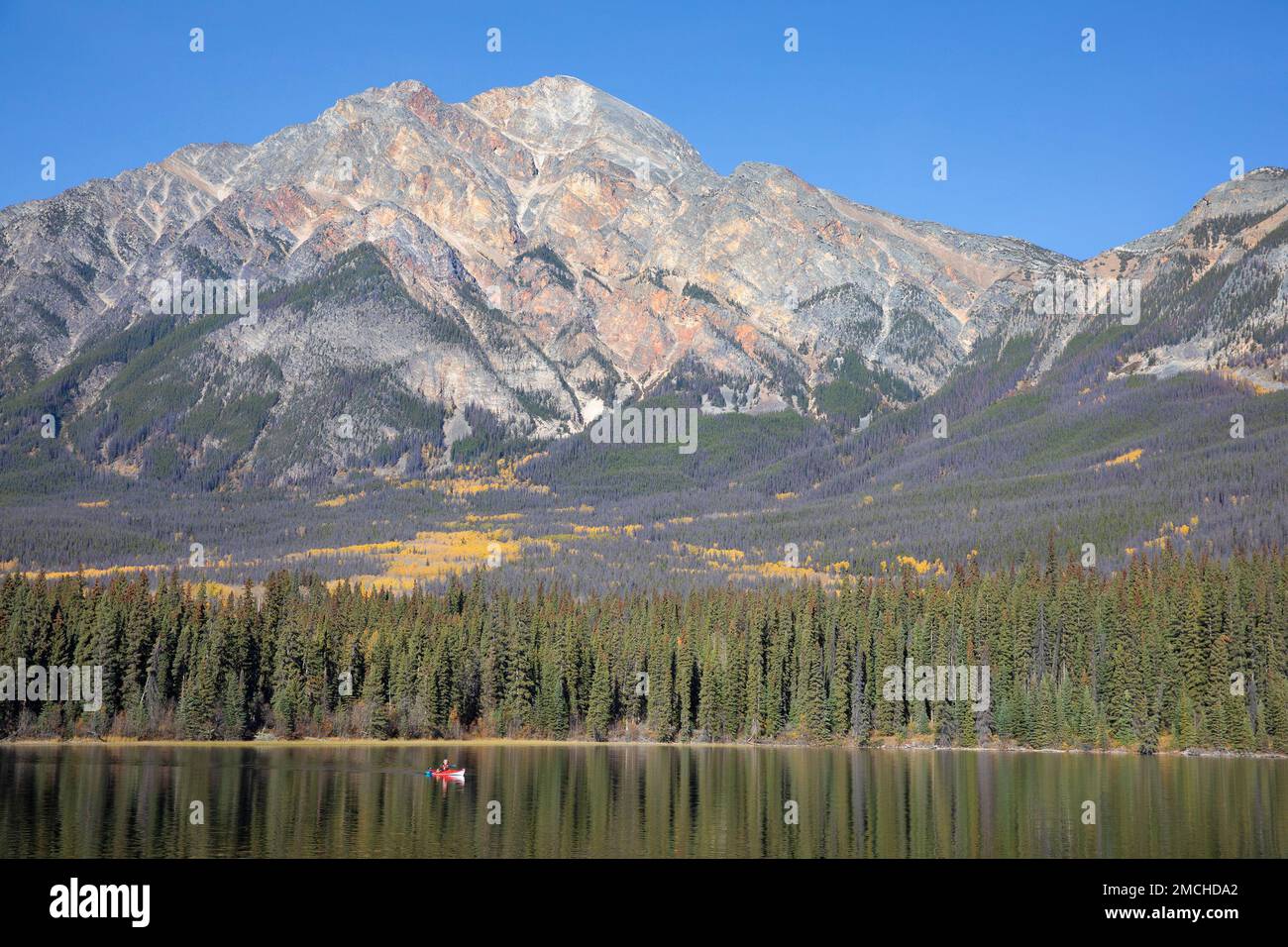 Person kayaking in Canadian Rocky Mountains on sunny day with view of ...