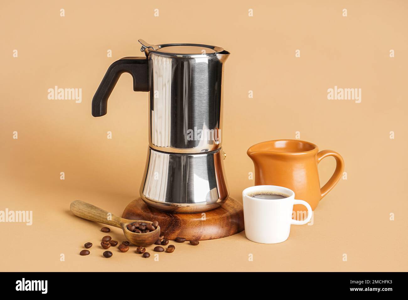 Geyser coffee maker, jug, beans and cup on beige background Stock Photo ...