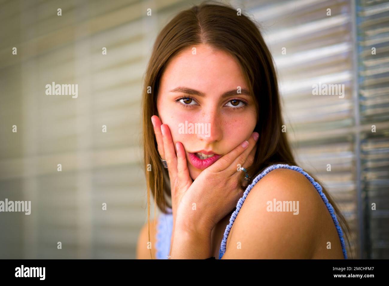 Close Up Portrait Of Teenage Girl Leaning Against Art Deco Glass Brick