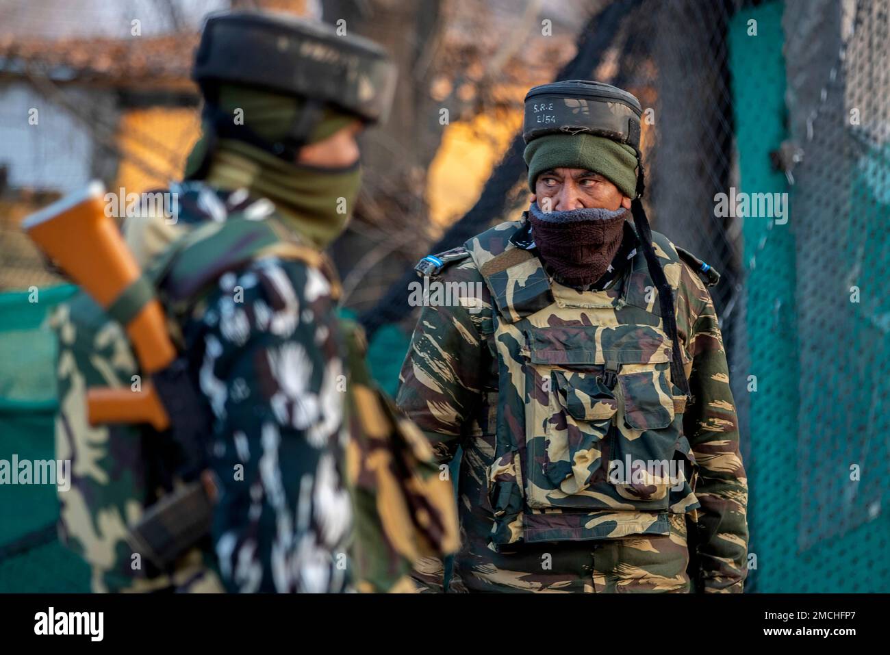 Indian paramilitary soldiers stand guard at a check point on a cold day ...