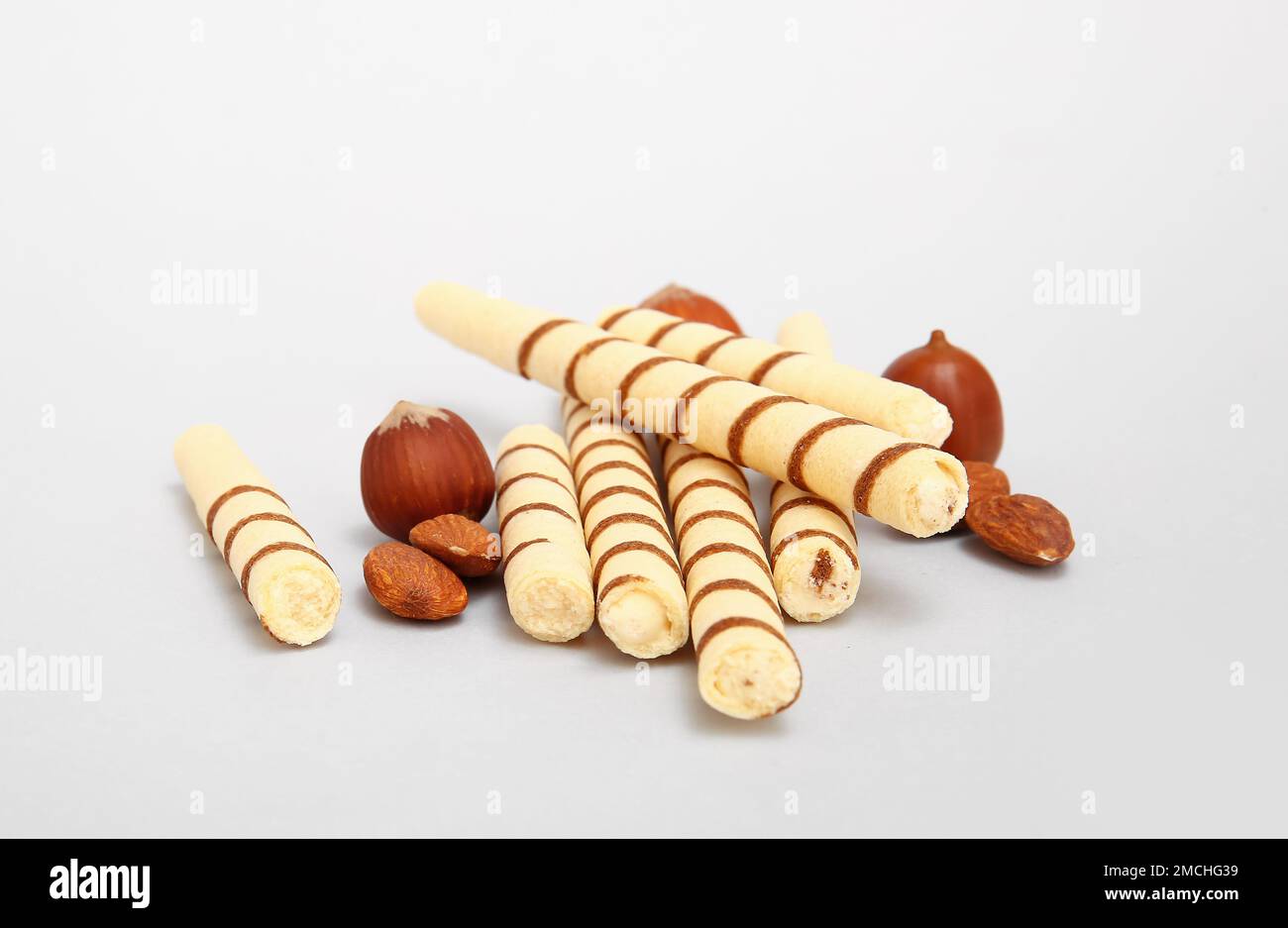 Tasty wafer rolls and nuts on grey background Stock Photo - Alamy