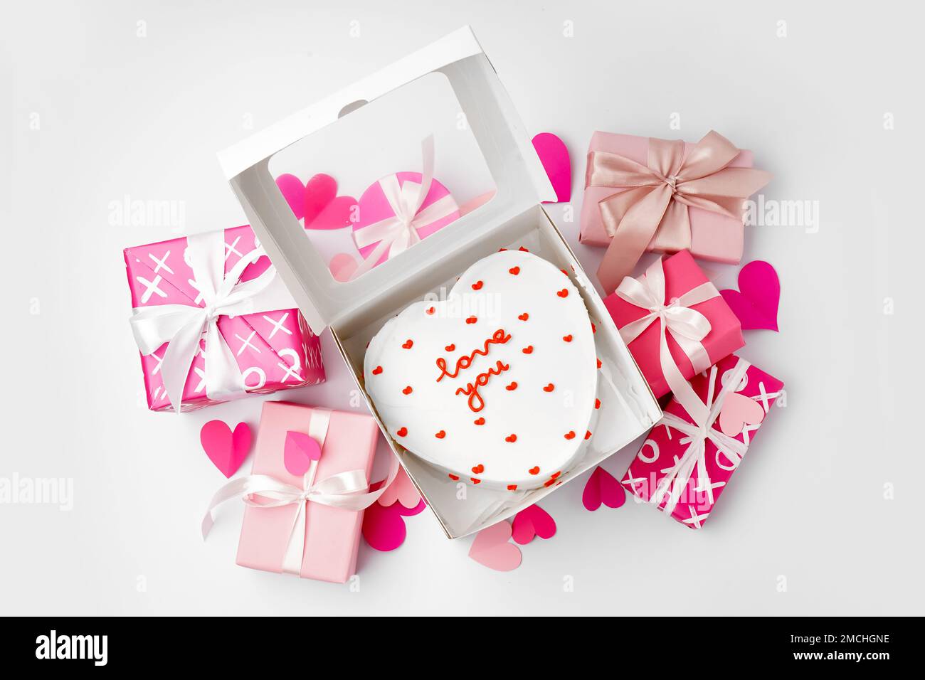 Box with heart-shaped bento cake, gifts and hearts isolated on white ...