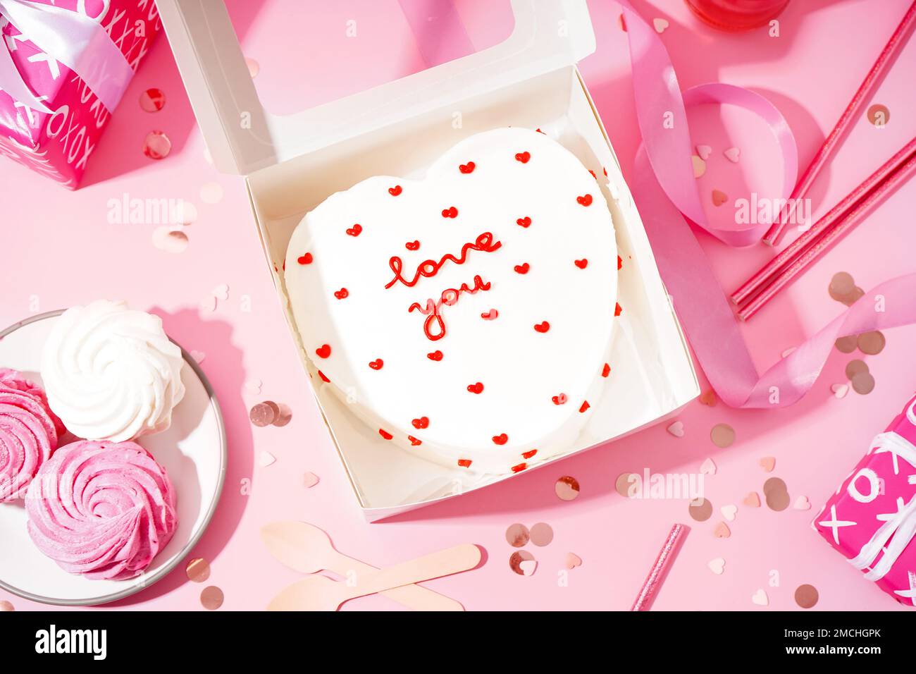 Box with heart-shaped bento cake, gifts and zephyr on pink background ...