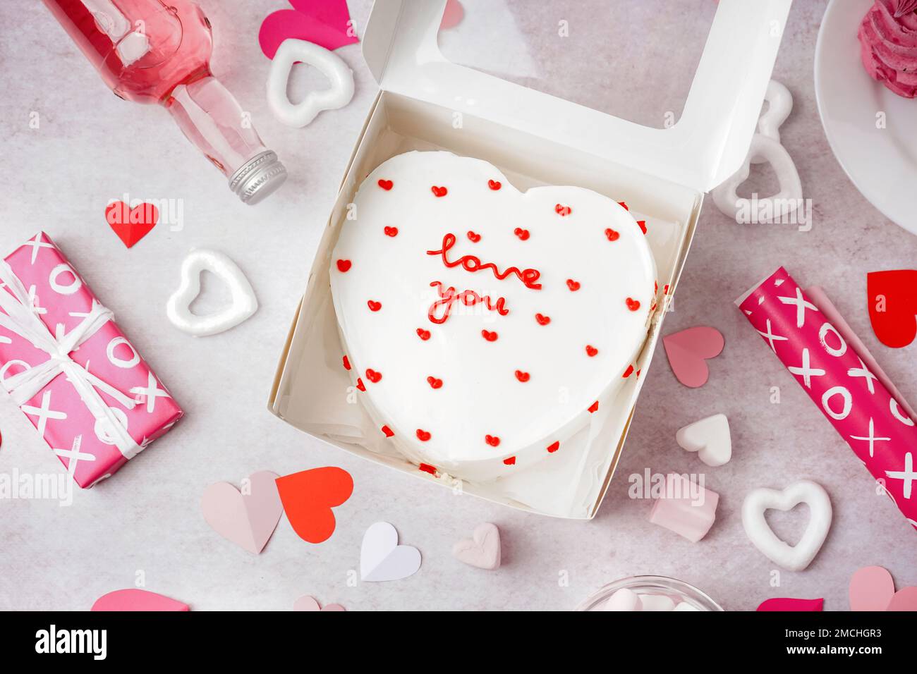 Box with heart-shaped bento cake and gift on white background ...
