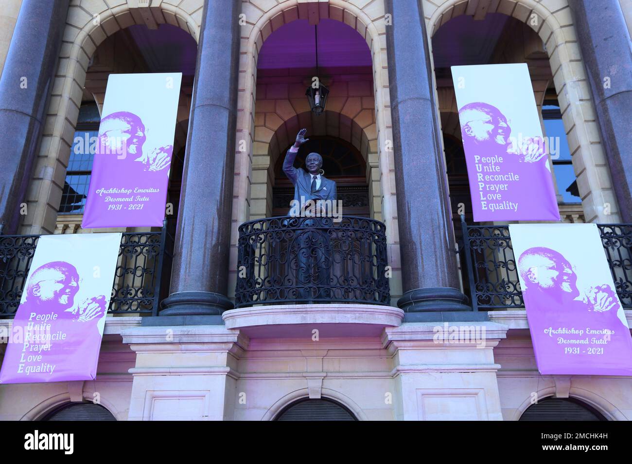 Portraits of Anglican Archbishop Emeritus Desmond Tutu, flanks a statue ...