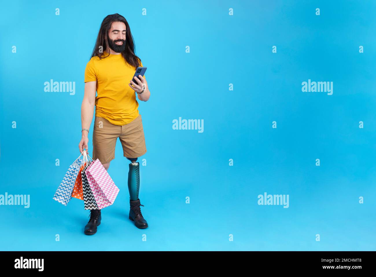 Man With Prosthetic Leg Using The Mobile Holing Shopping Bags Stock 8693