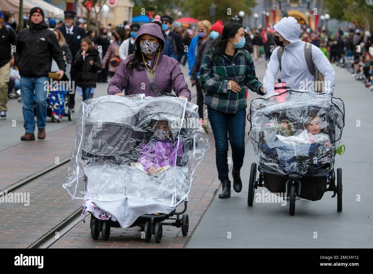 Visitors wearing face masks walk down Main Street USA at Disneyland in ...