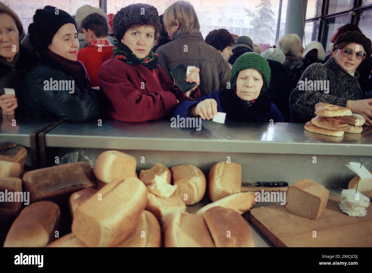 FILE - Several women wait with their tickets in hand, for fresh bread ...