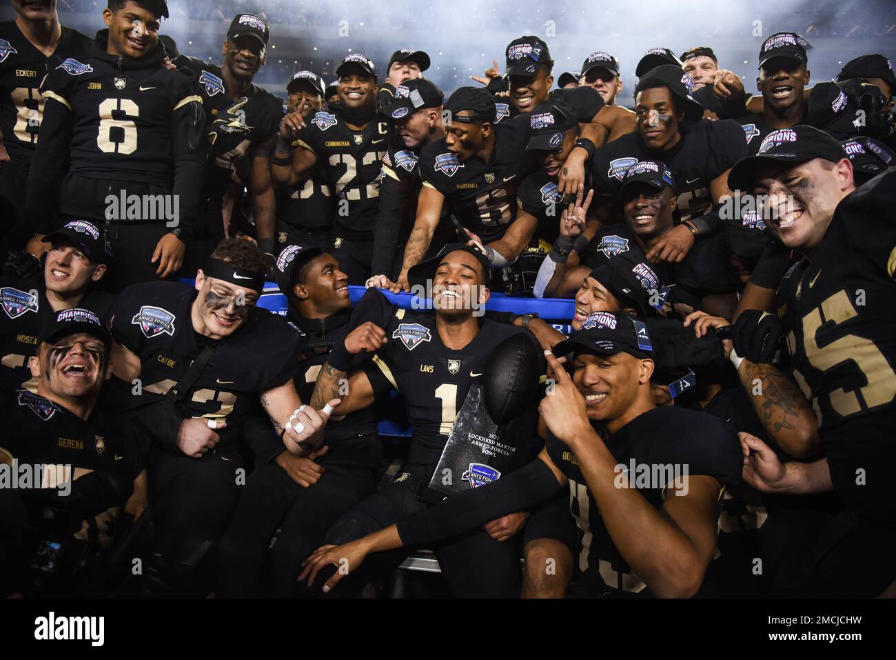 The Army football team poses for photos with the trophy after winning ...