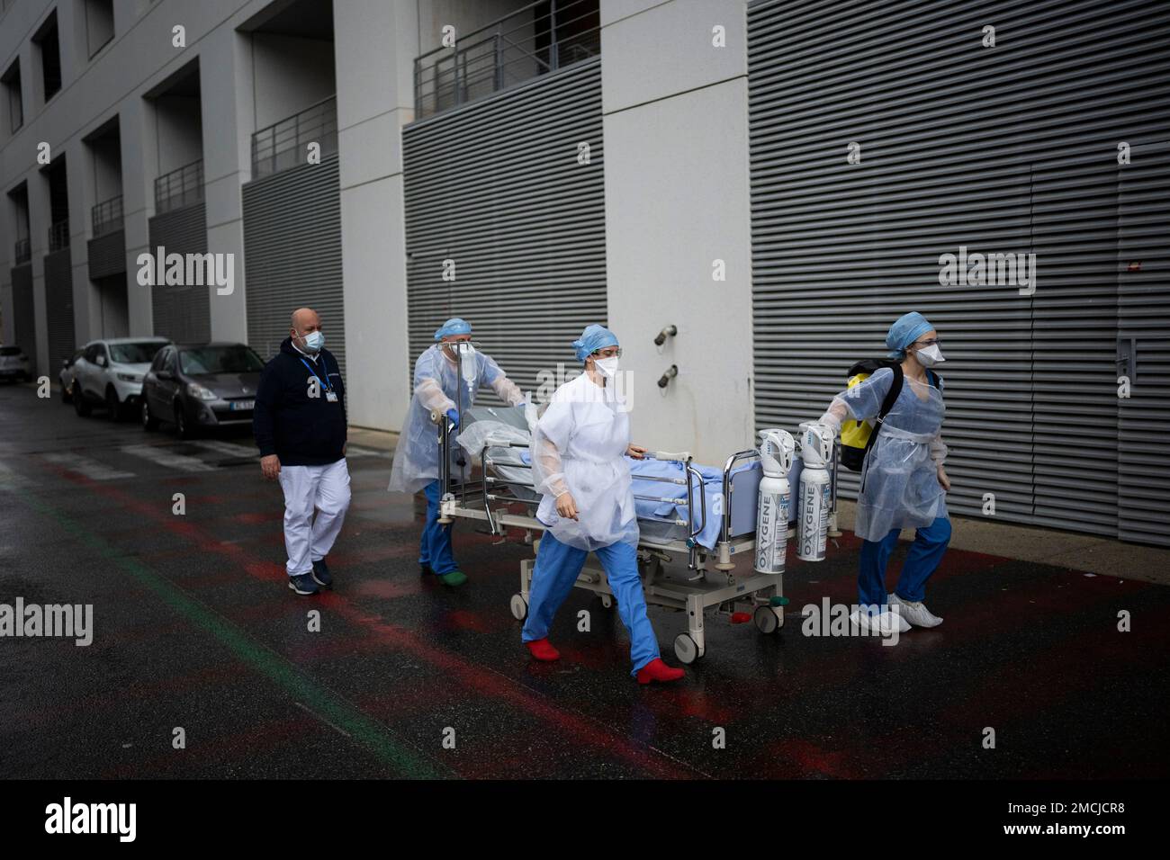Medical workers transport a COVID-19 patient into the COVID-19 ...