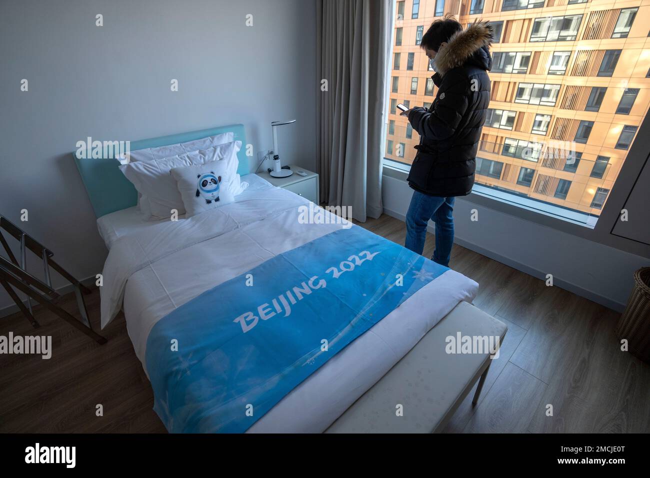 A journalist looks at a bed in an athletes' bedroom at the Winter ...
