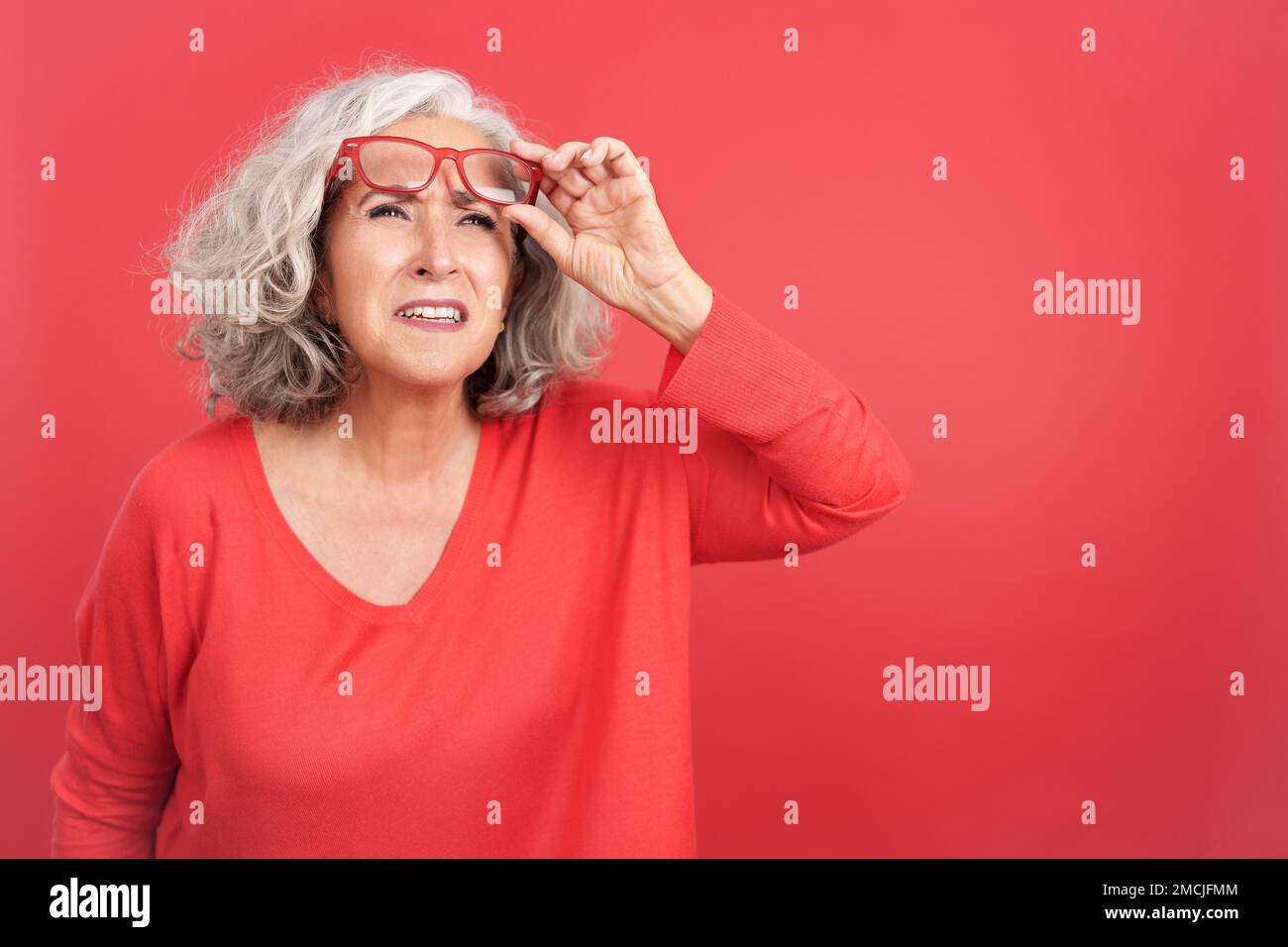 Woman lifting up her glasses to see from a distance Stock Photo - Alamy