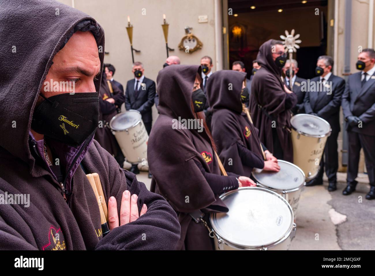 People walk, play music and carry wooden sculptures through the streets ...