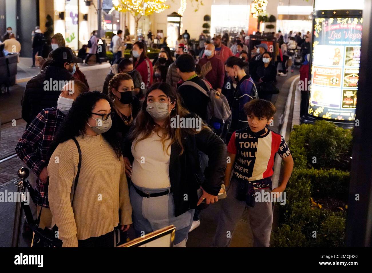 Visitors wear face masks while waiting to board a trolley at a shopping ...