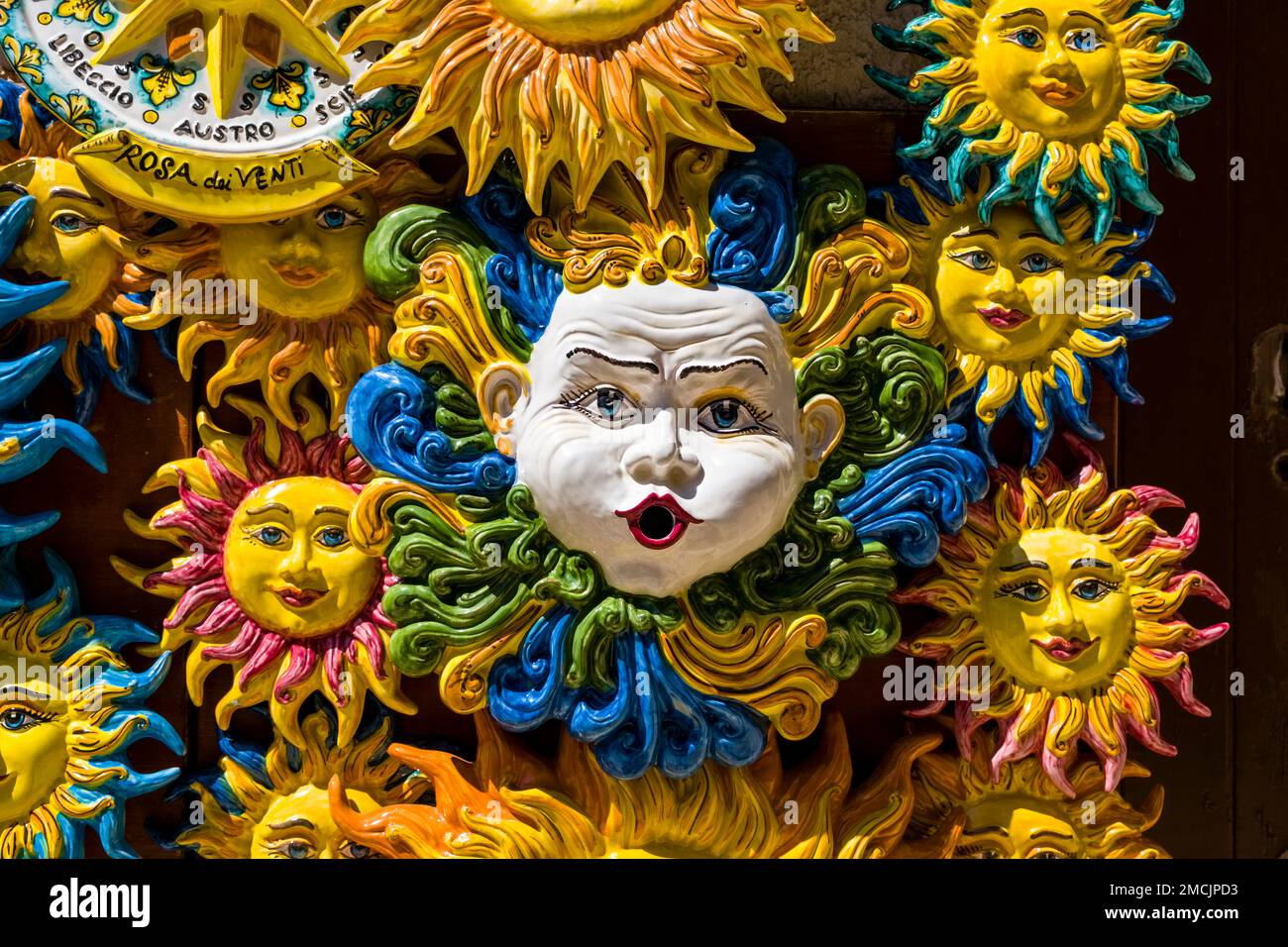 Colorfully painted terracotta sun symbols are for sale in the souvenir ...