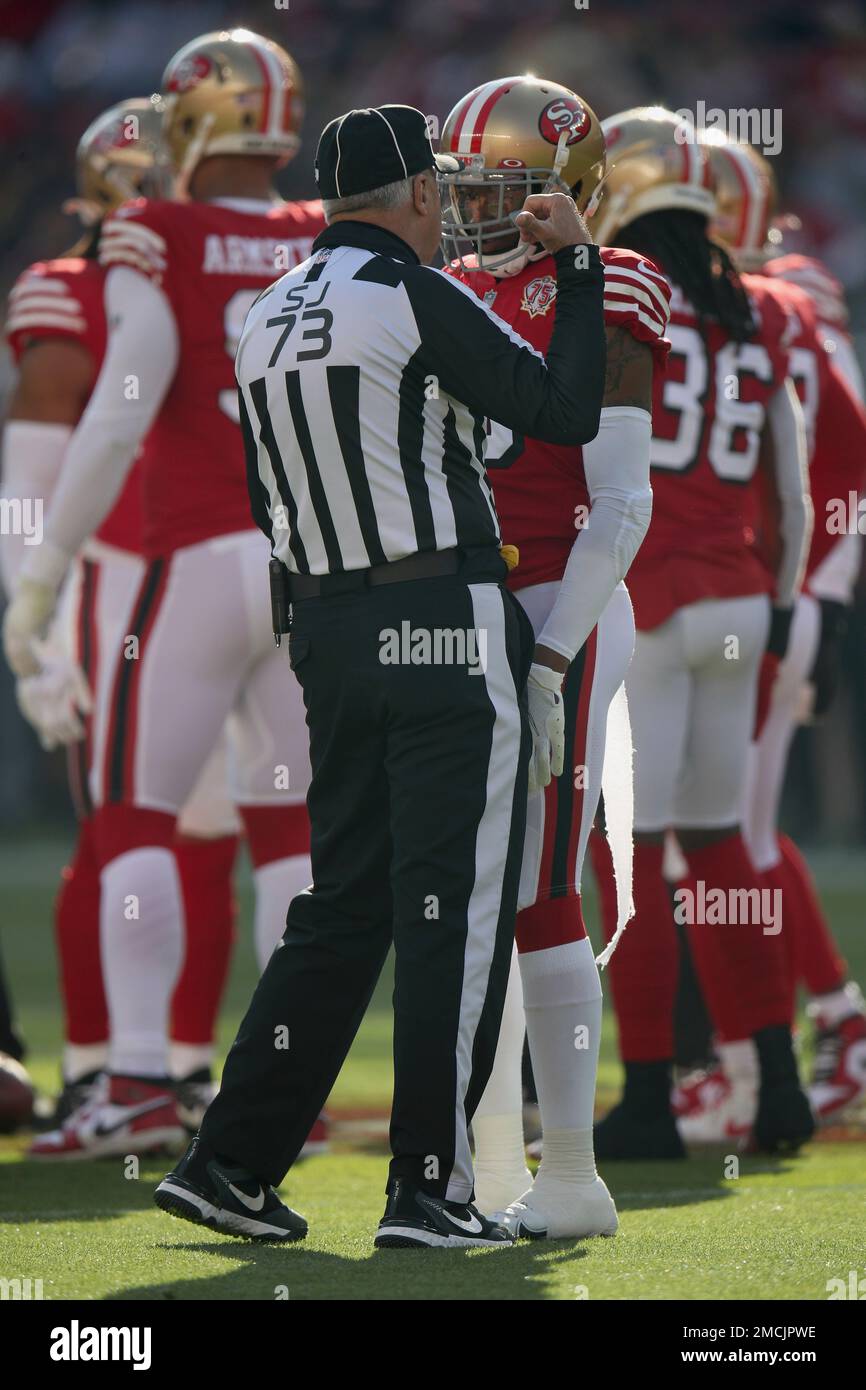 Side judge Joe Larrew (73) speaks with San Francisco 49ers cornerback ...