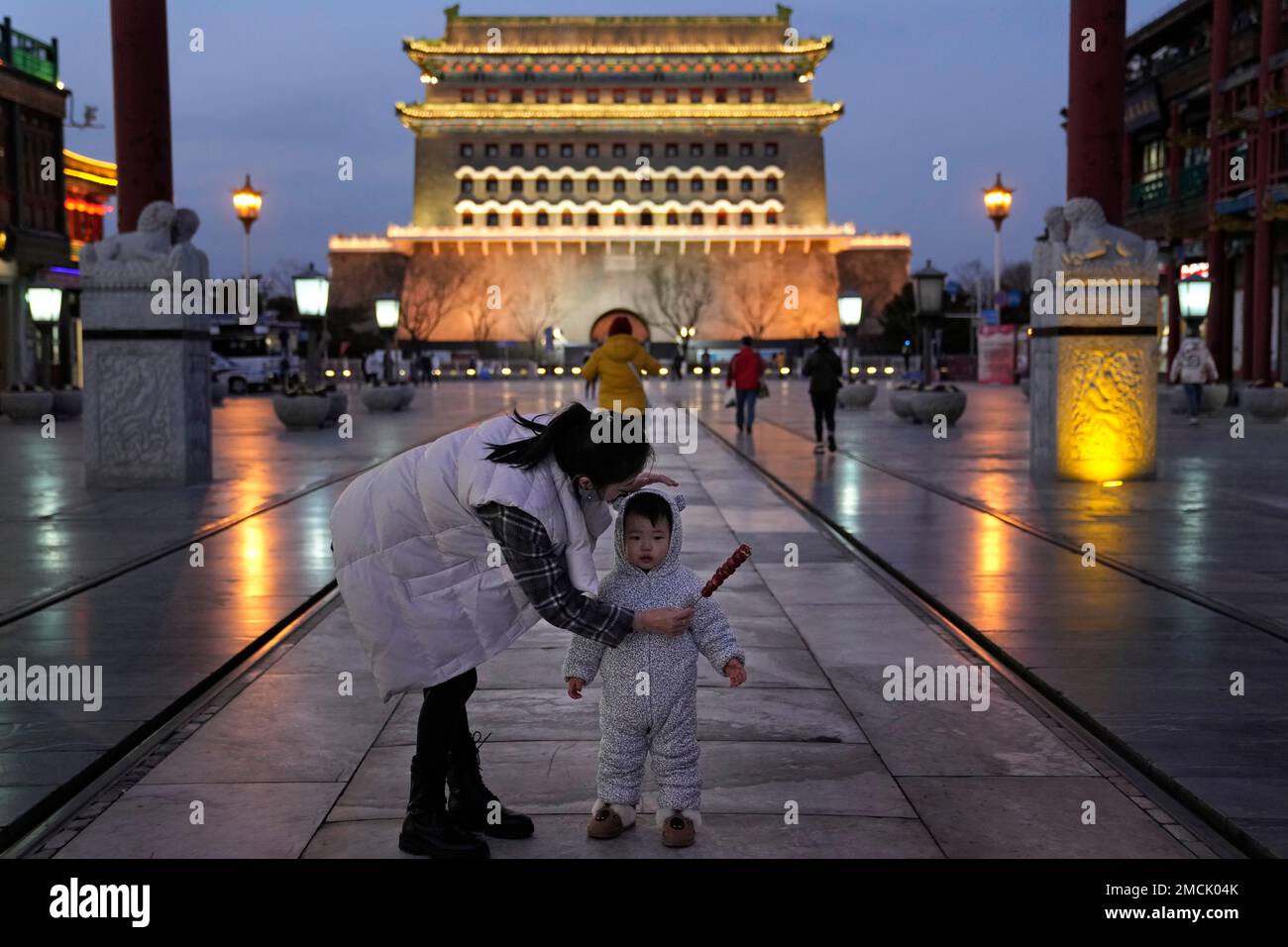 A woman positions a child for a photo at the Qianmen retail street in ...