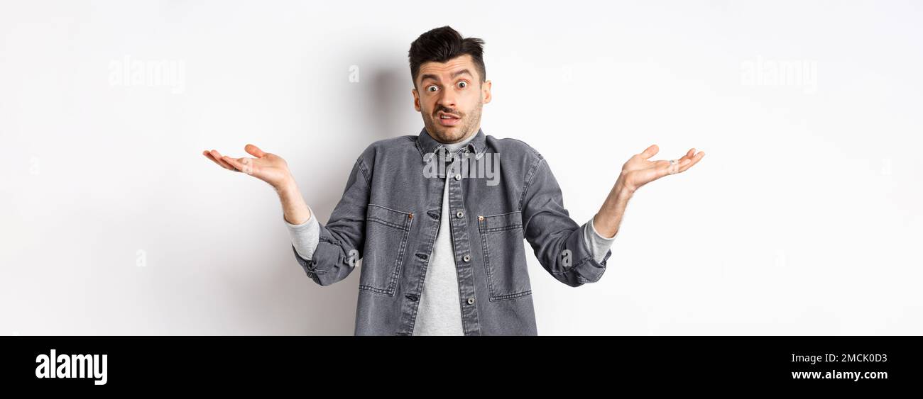 I dont know. Clueless young man shrugging and looking confused, have ...