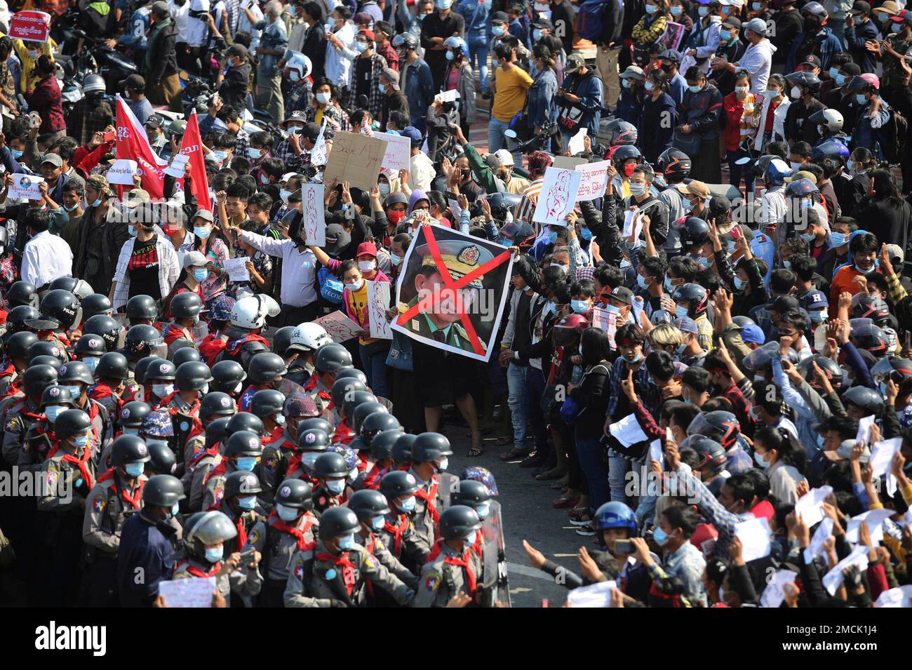 Protesters flashing three fingered salutes and holding an image with an ...